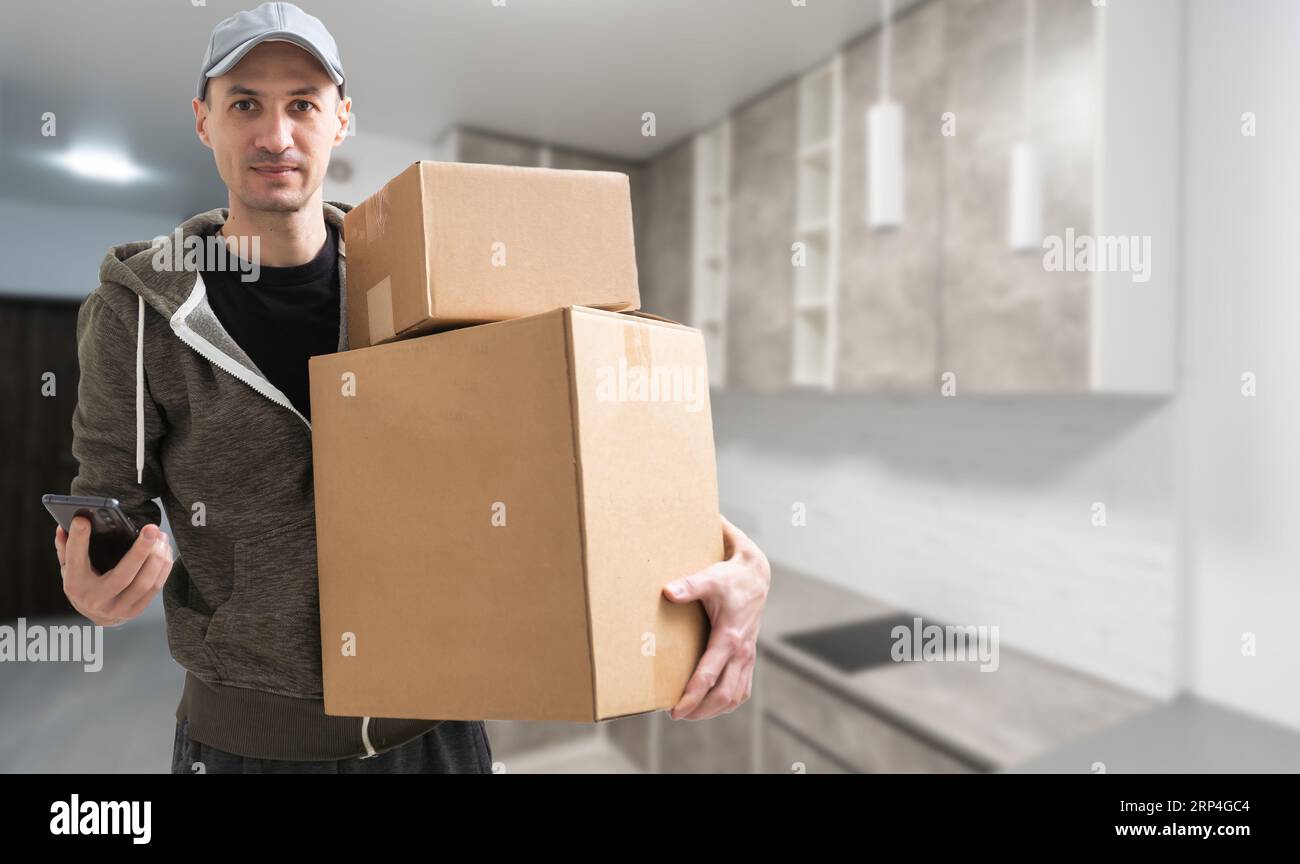 Man lifting cardboard boxes in apartment interior Stock Photo - Alamy