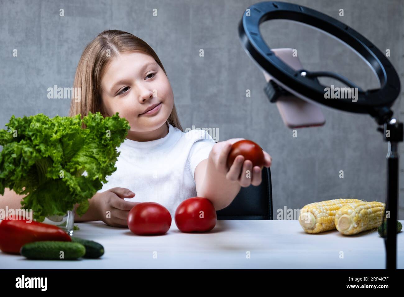 A beautiful blond teenage girl broadcasts live about healthy eating ...