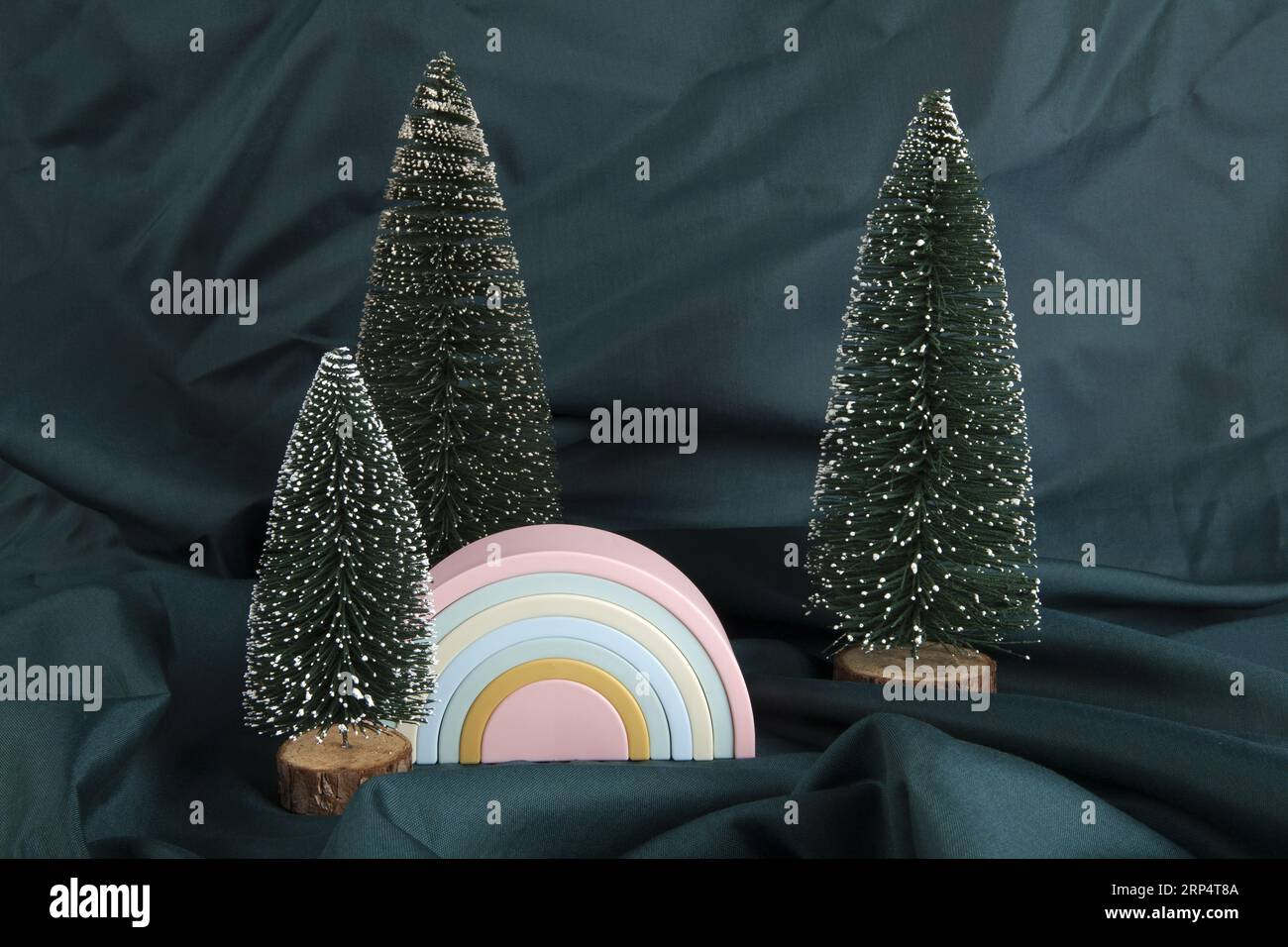 a plastic rainbow toy amid a forest of miniature, snow-covered ...