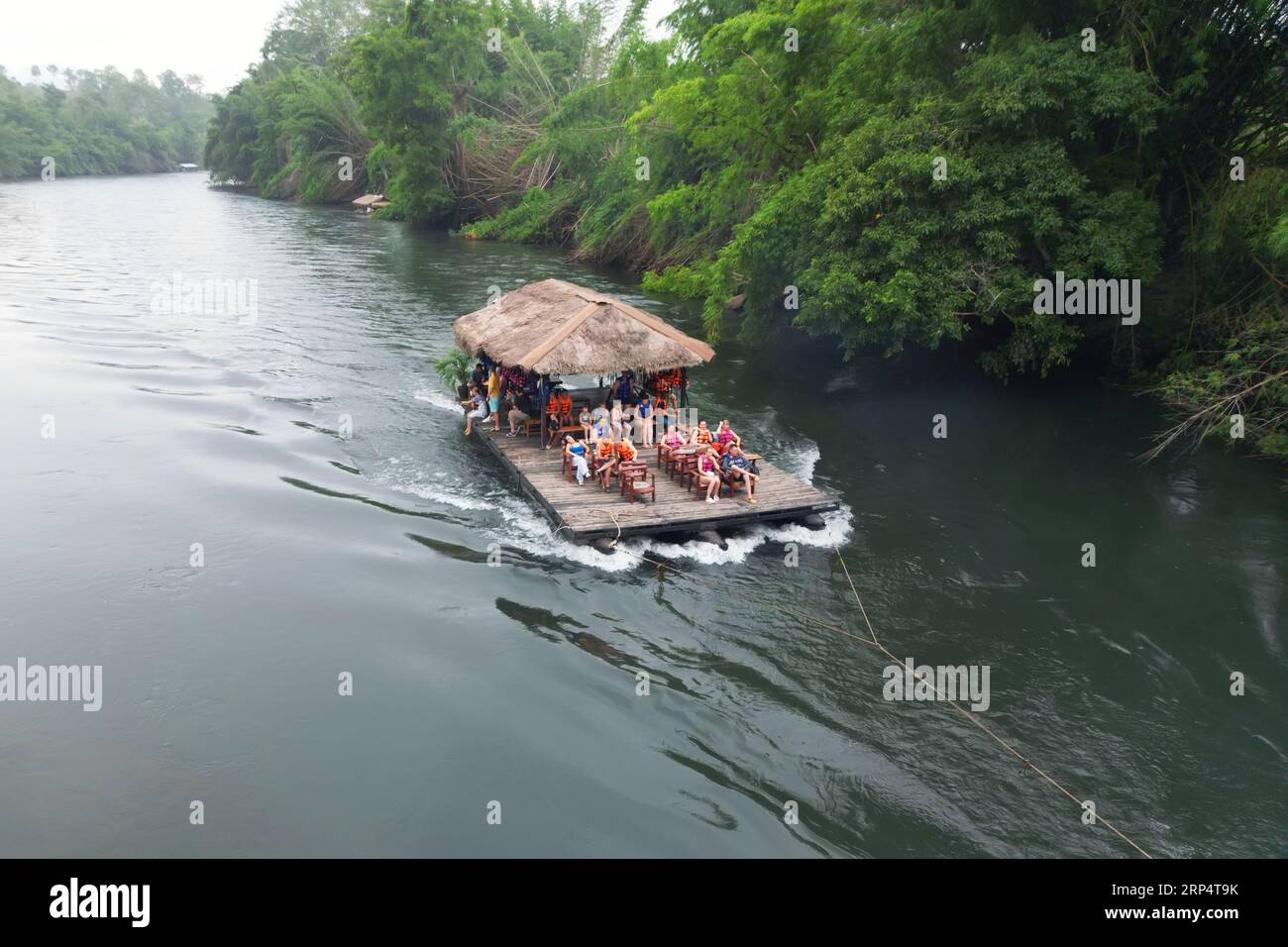 Top view of Long tail boat dragging wooden raft near waterfall flowing ...