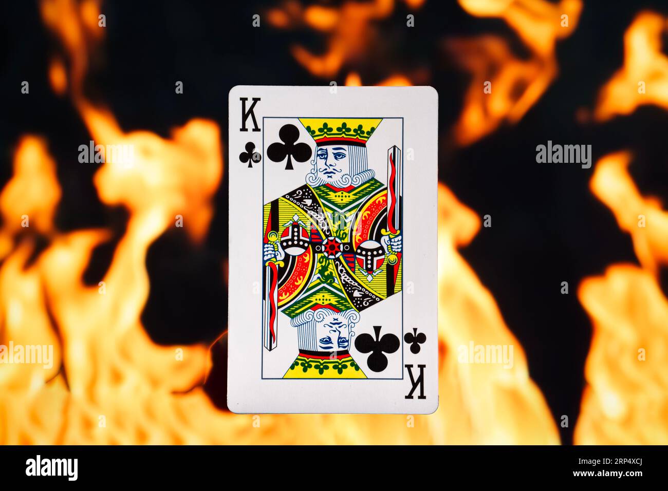 King of spades playing card in sharp focus with blazing fire in the ...