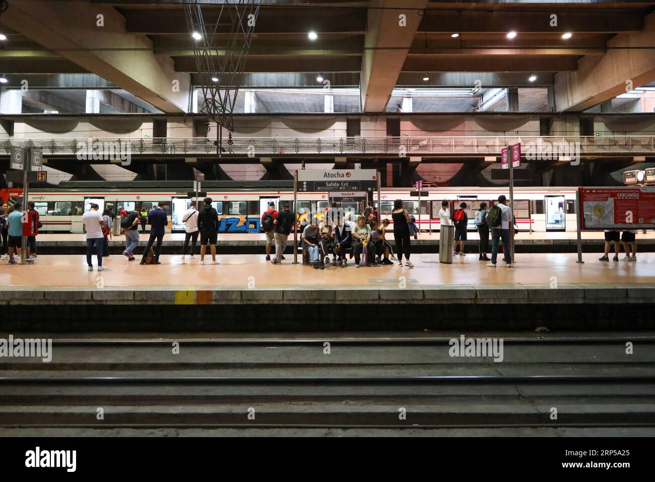 People wait for a train on the platforms of the Atocha suburban station ...