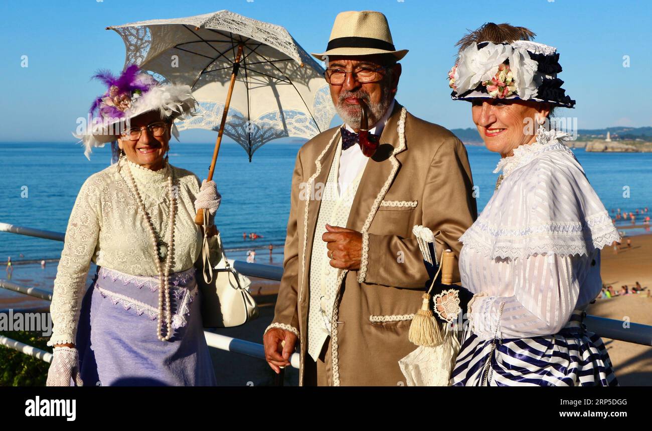 Two women and a man dressed Victorian style for the annual Banos de Ola ...