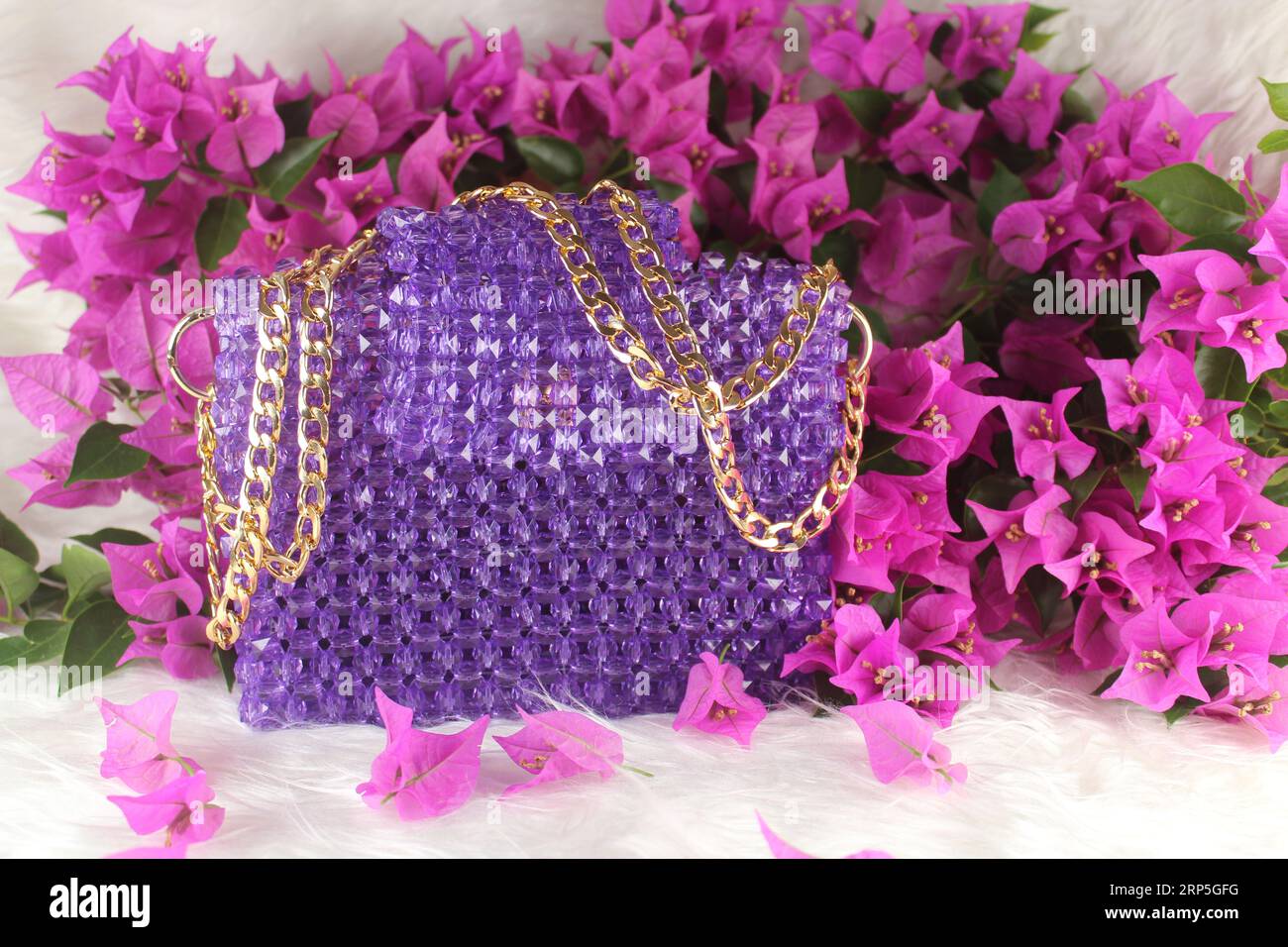 Handmade purple purse made with bright beads on white furry blanket ...