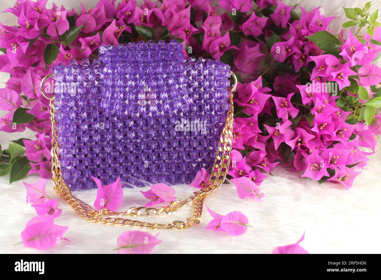 Handmade purple purse made with bright beads on white furry blanket ...