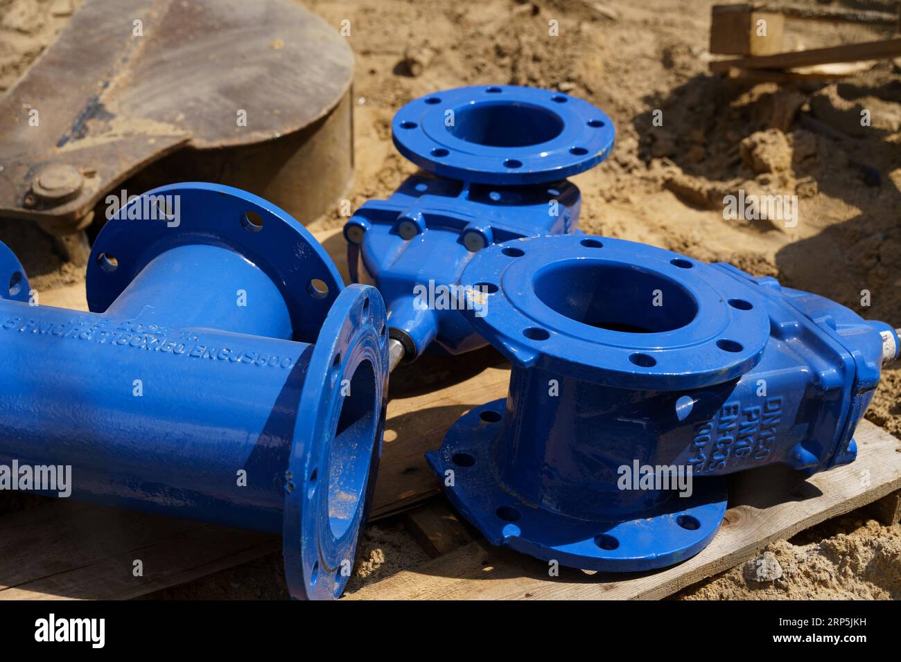 On the construction site there is sewage equipment - a tee and blue ...