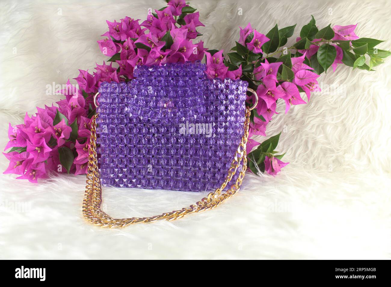 Handmade purple purse made with bright beads on white furry blanket ...