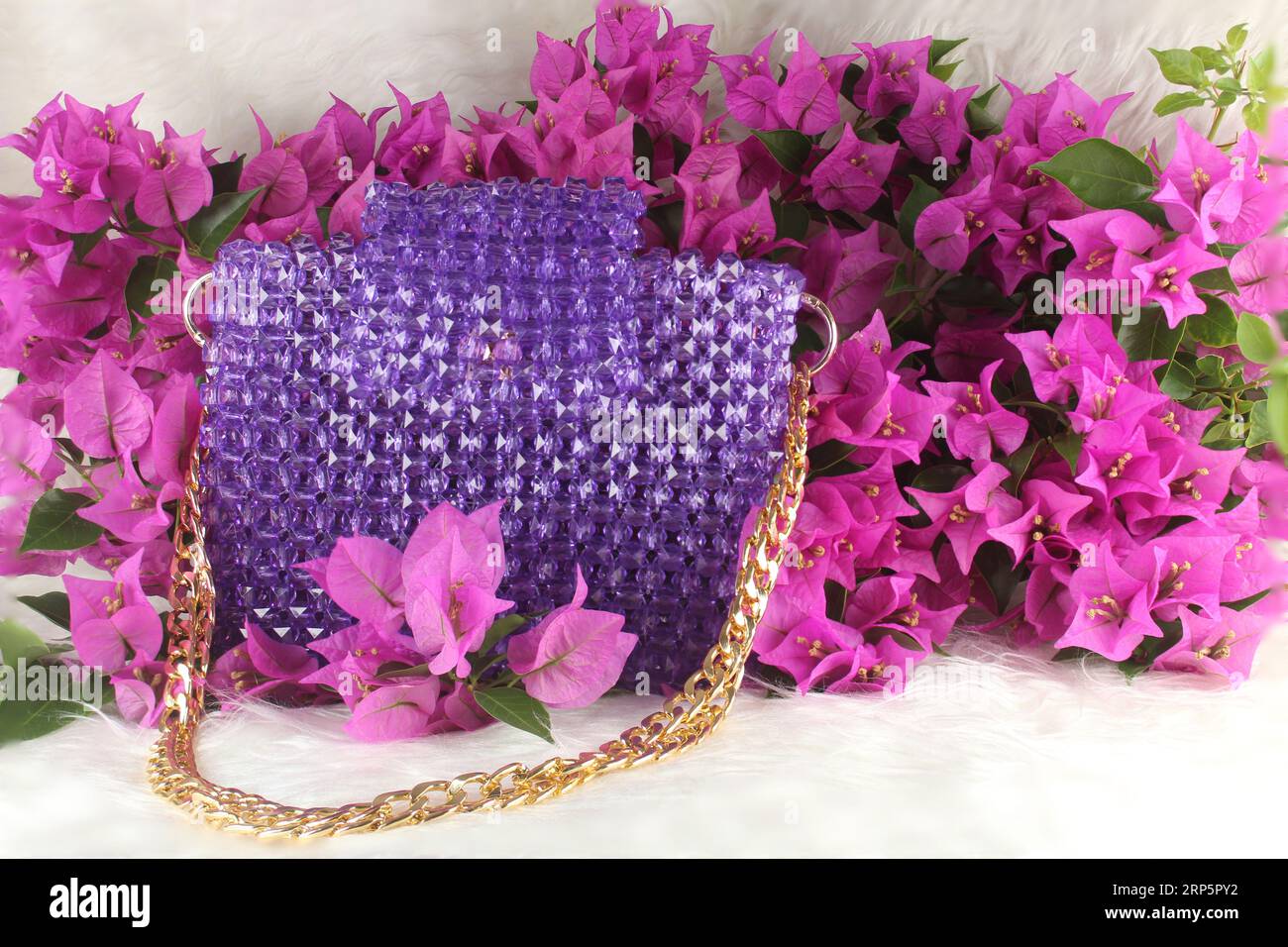 Handmade purple purse made with bright beads on white furry blanket ...