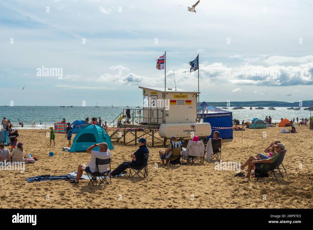 Bournemouth, UK - September 1st 2023: people sitting on the beach ...