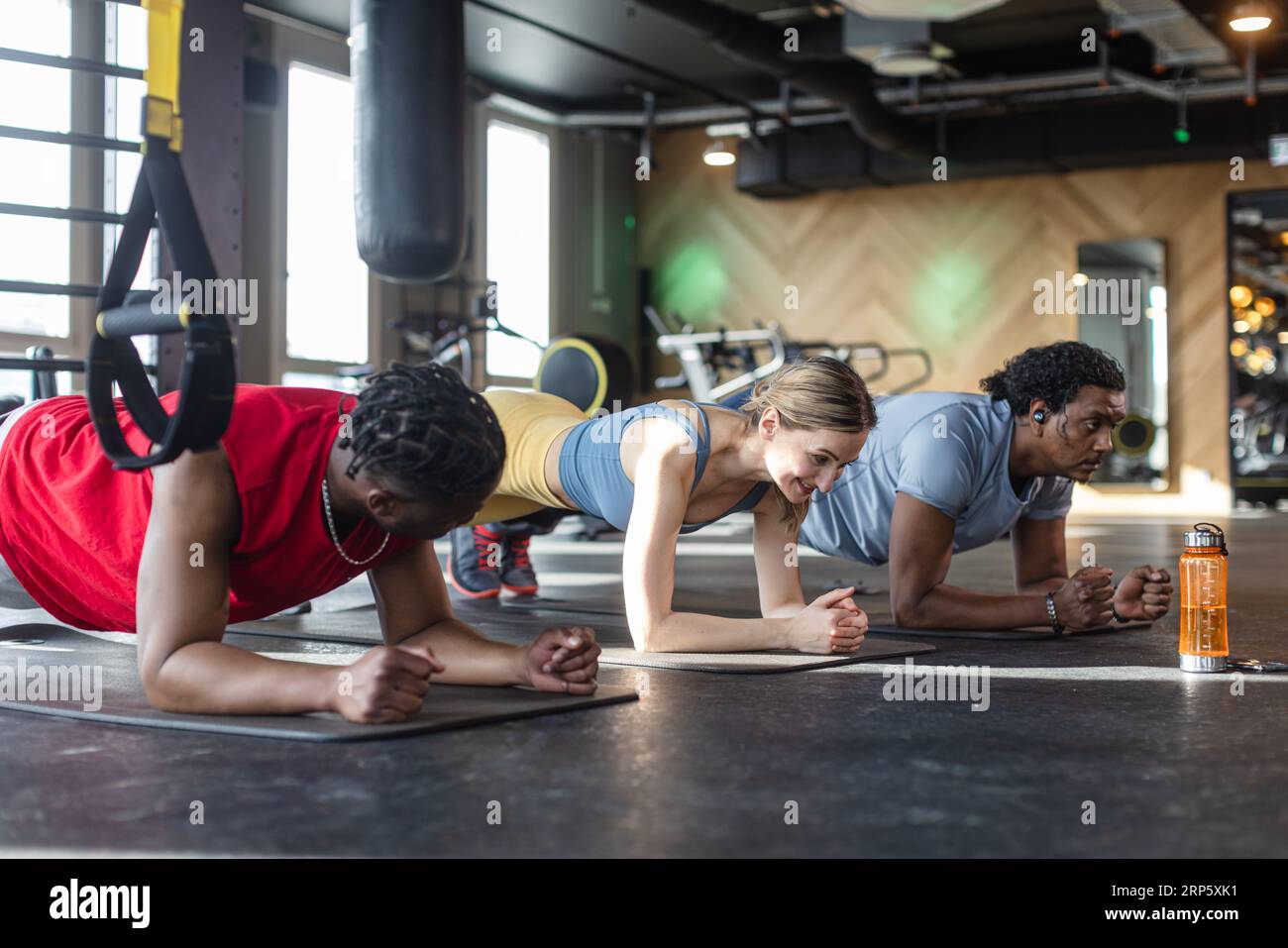 Three diverse people doing planks in gym Stock Photo - Alamy