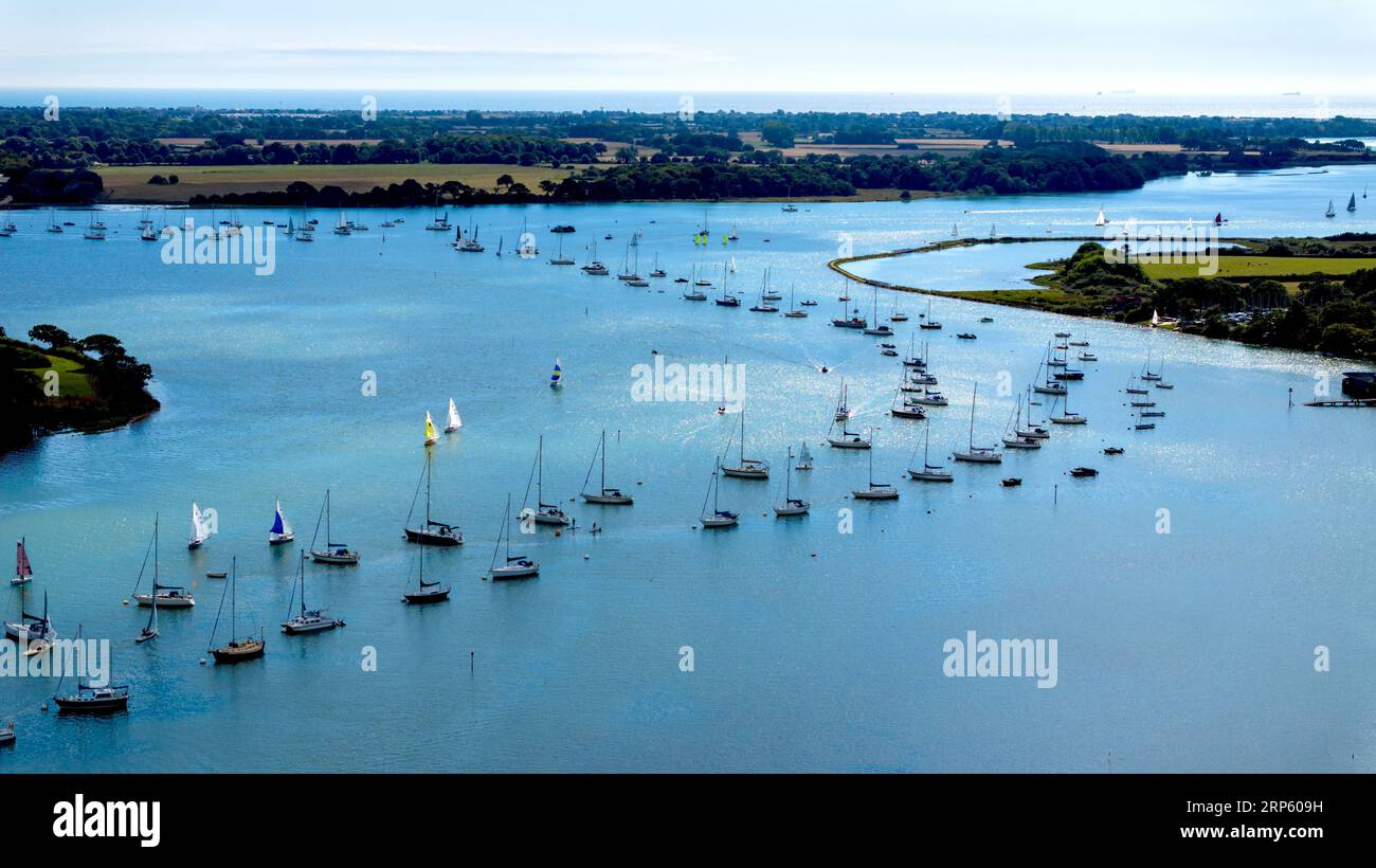 Aerial view of the Bosham channel in Chichester harbour. Lines of yachts and other boats moored ...