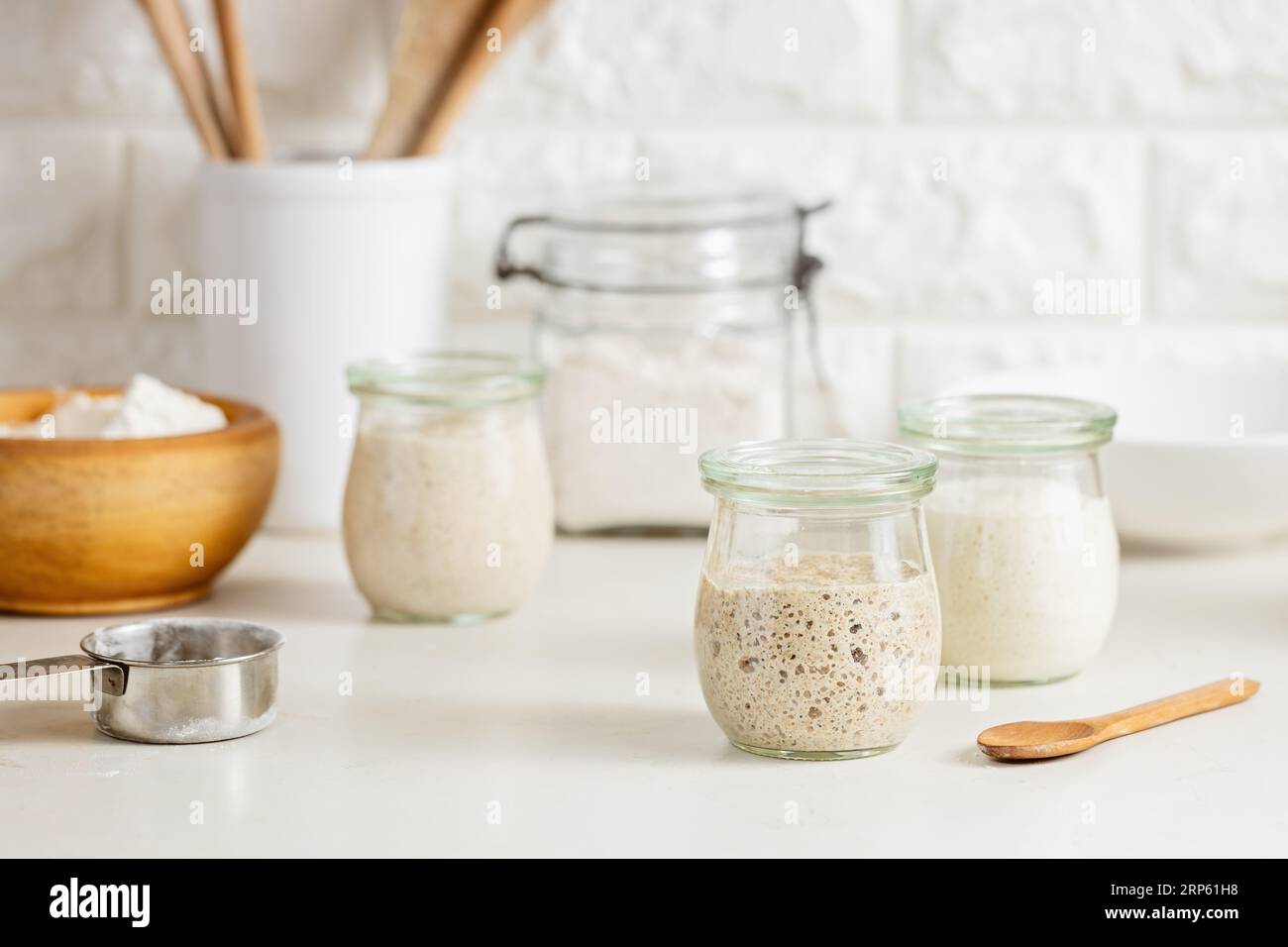 Glass jars with active sourdough starter on table Stock Photo - Alamy