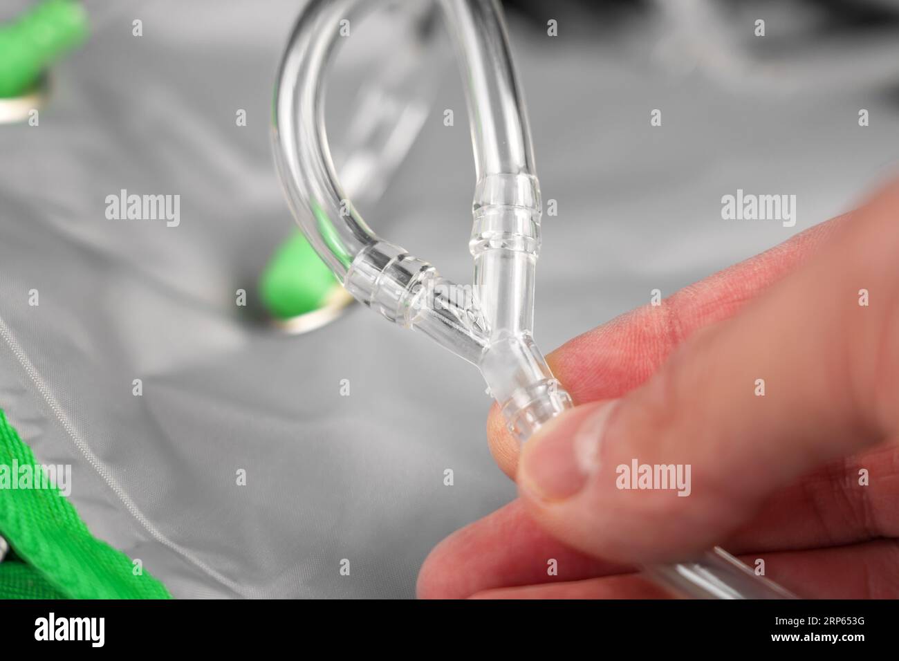 Pneumatic transparent tube splitter. Plastic connector in hand close up ...