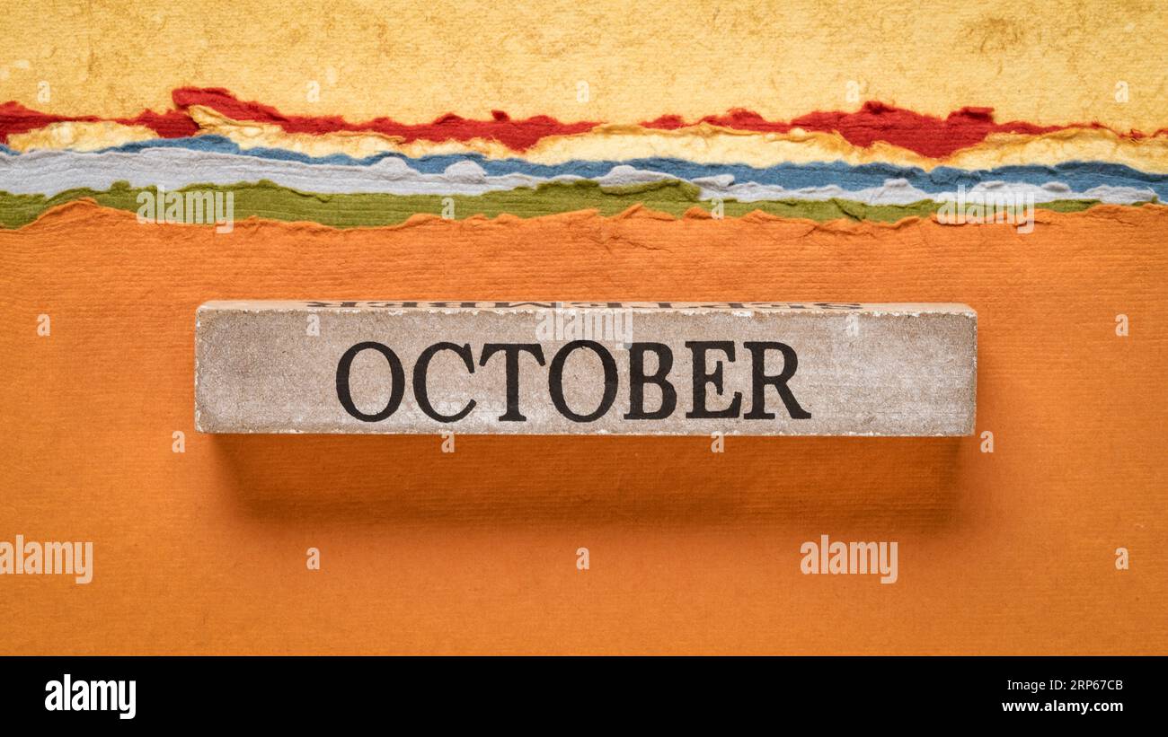 October text on grunge wooden block against handmade rag papers ...