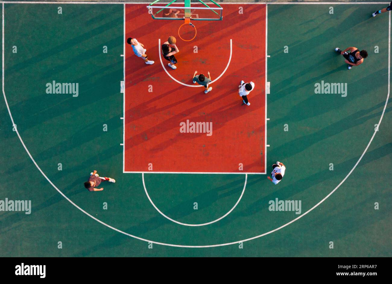 An outdoor basketball court with a vibrant green playing surface ...