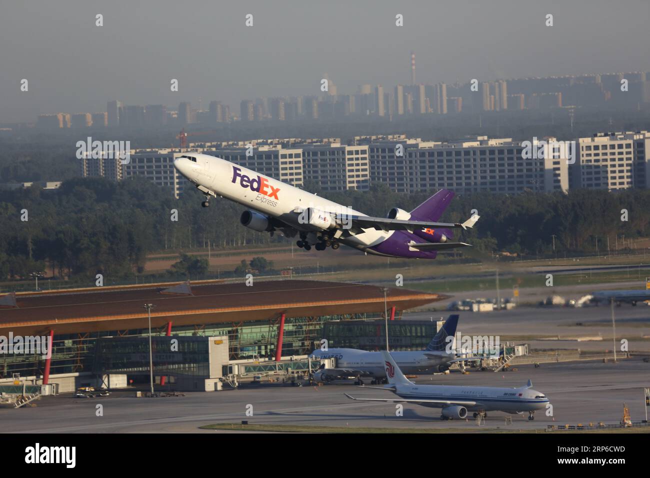 A FedEx aircraft is seen taking off from a busy runway in a bustling ...