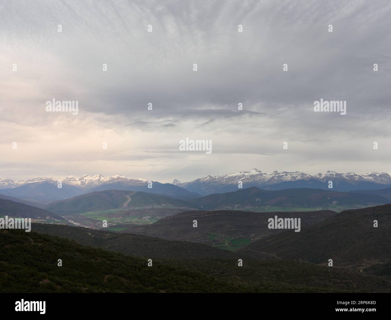 A scenic mountain range in the daylight with a valley below ...