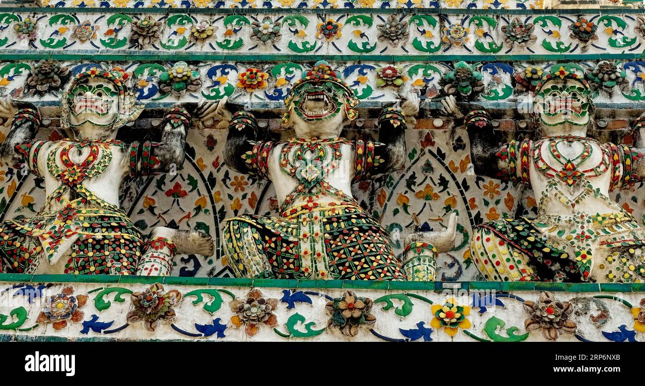 Three ornate statues on a temple wall. The statues are of three figures ...