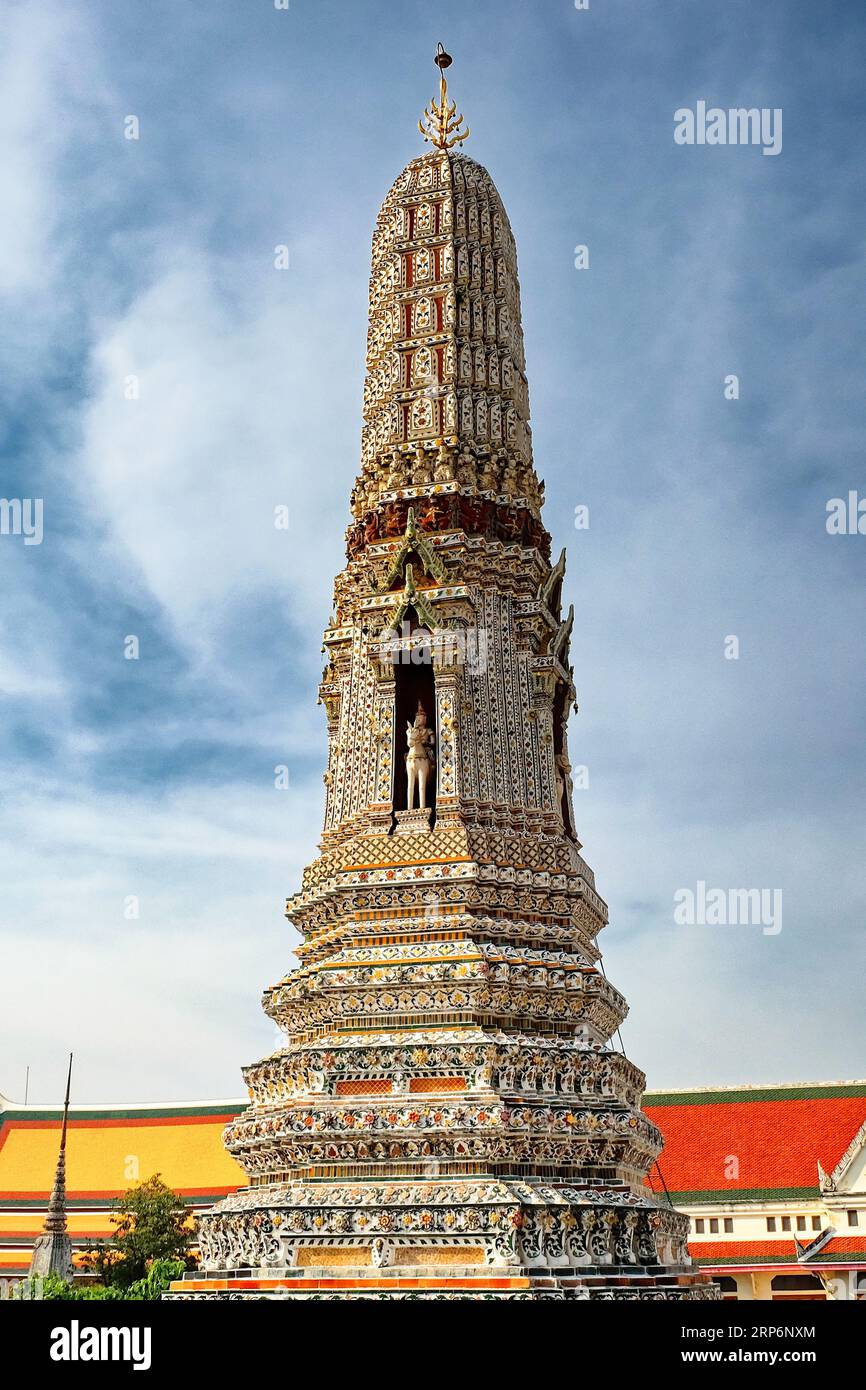 A temple in Thailand. The temple is a tall, ornate structure with many ...