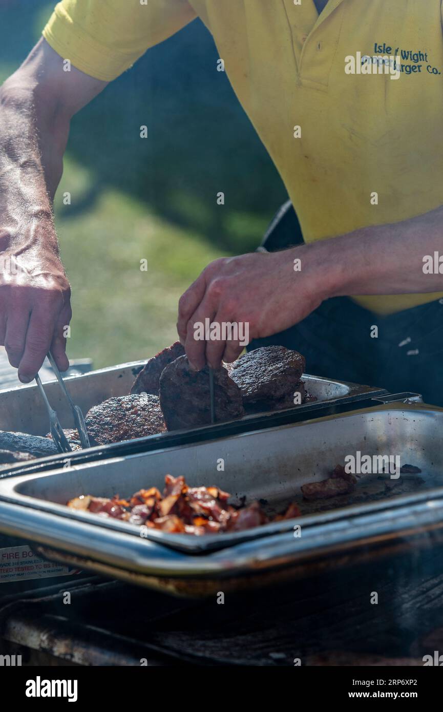 bacon sausages and beefburgers being cooked on a barbeque grill Stock ...