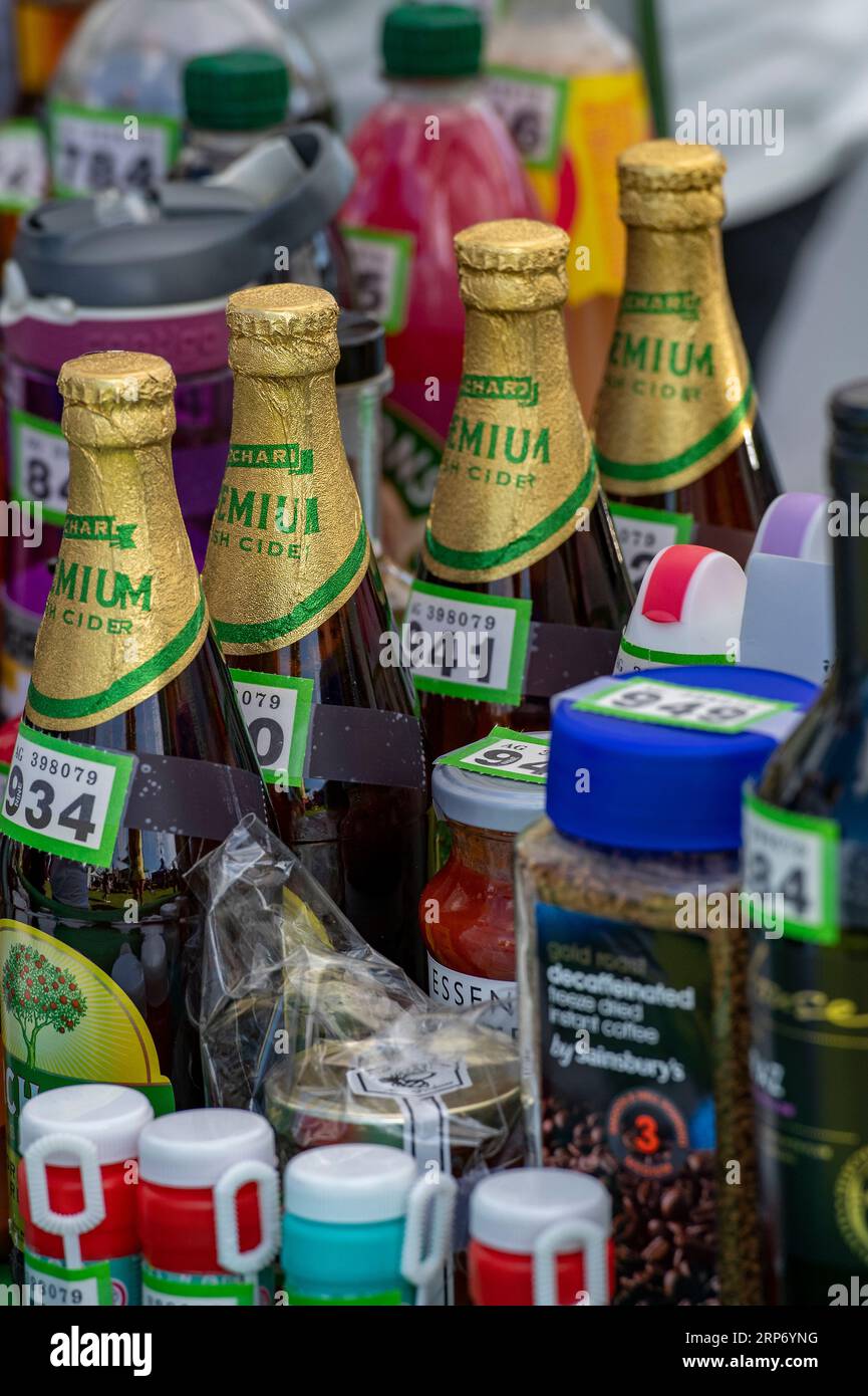 bottles and jars of alcohol and food on a tombola stall at a country ...