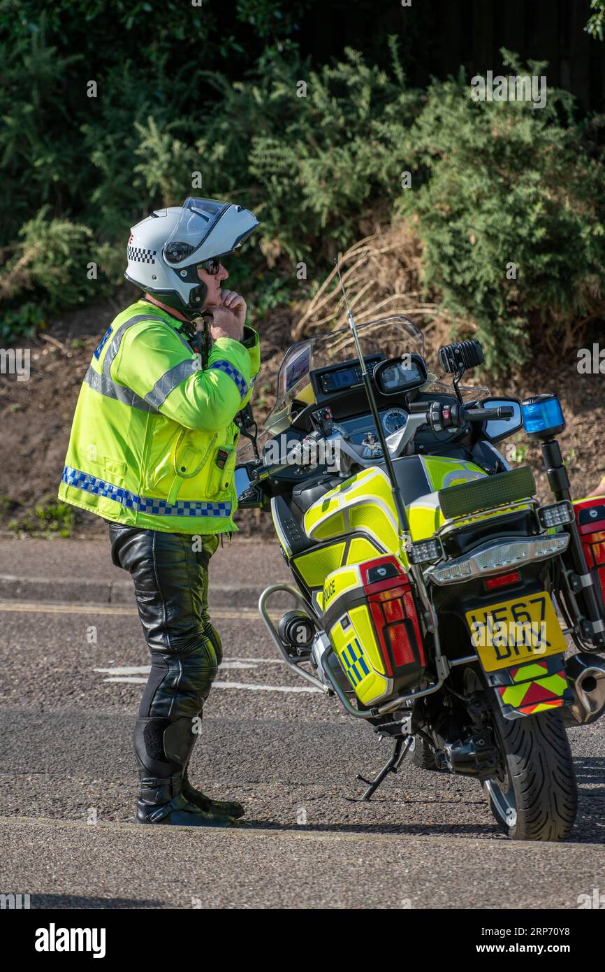 traffic police motorcycle officer standing next to his bike putting on ...