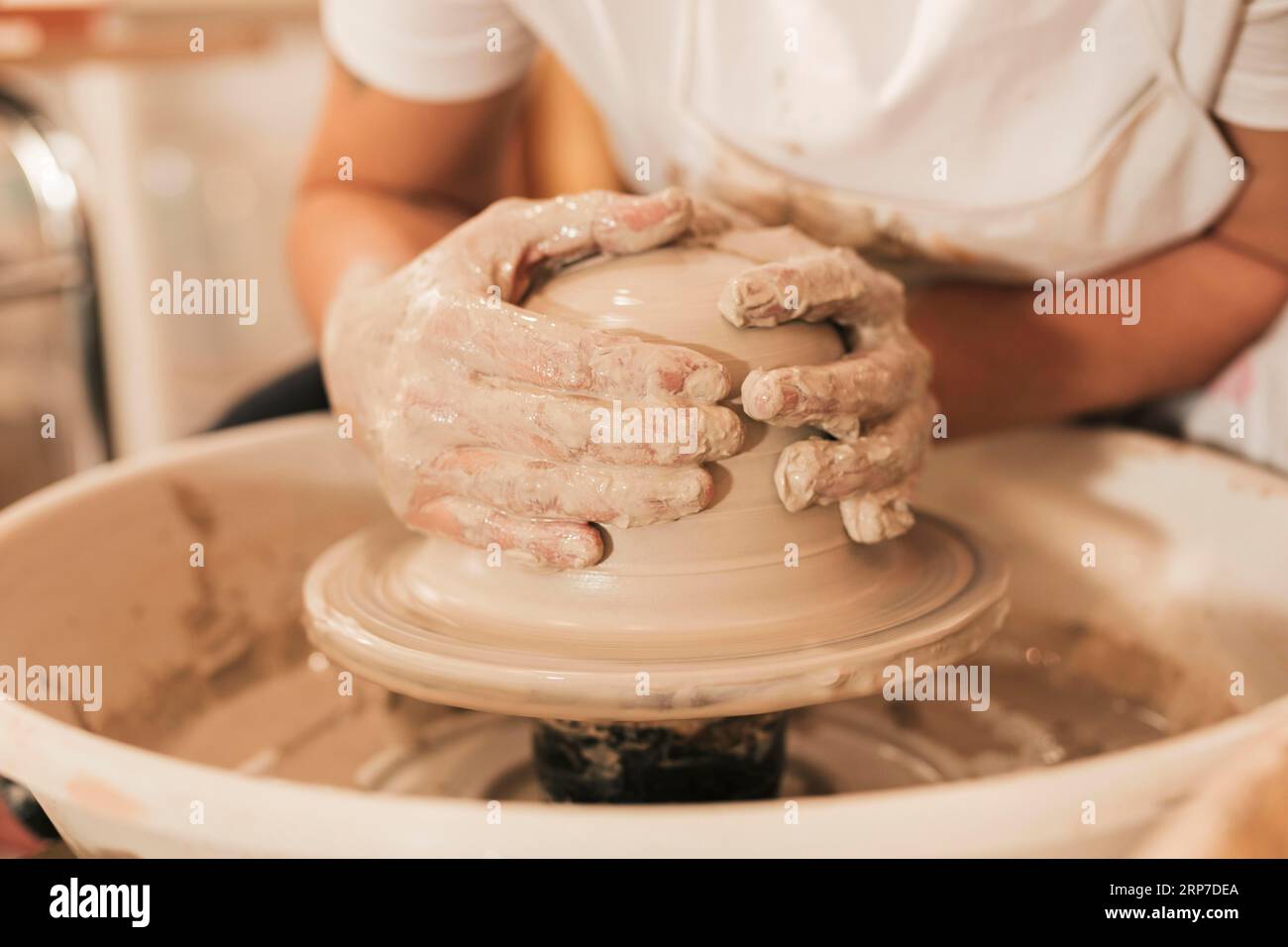 Craftswoman creating pottery working wheel shaping clay Stock Photo - Alamy