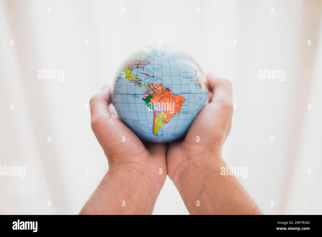 Person s hand holding small globe Stock Photo - Alamy