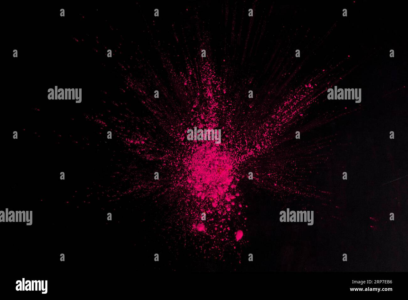 Overhead view pink color exploding black surface Stock Photo - Alamy