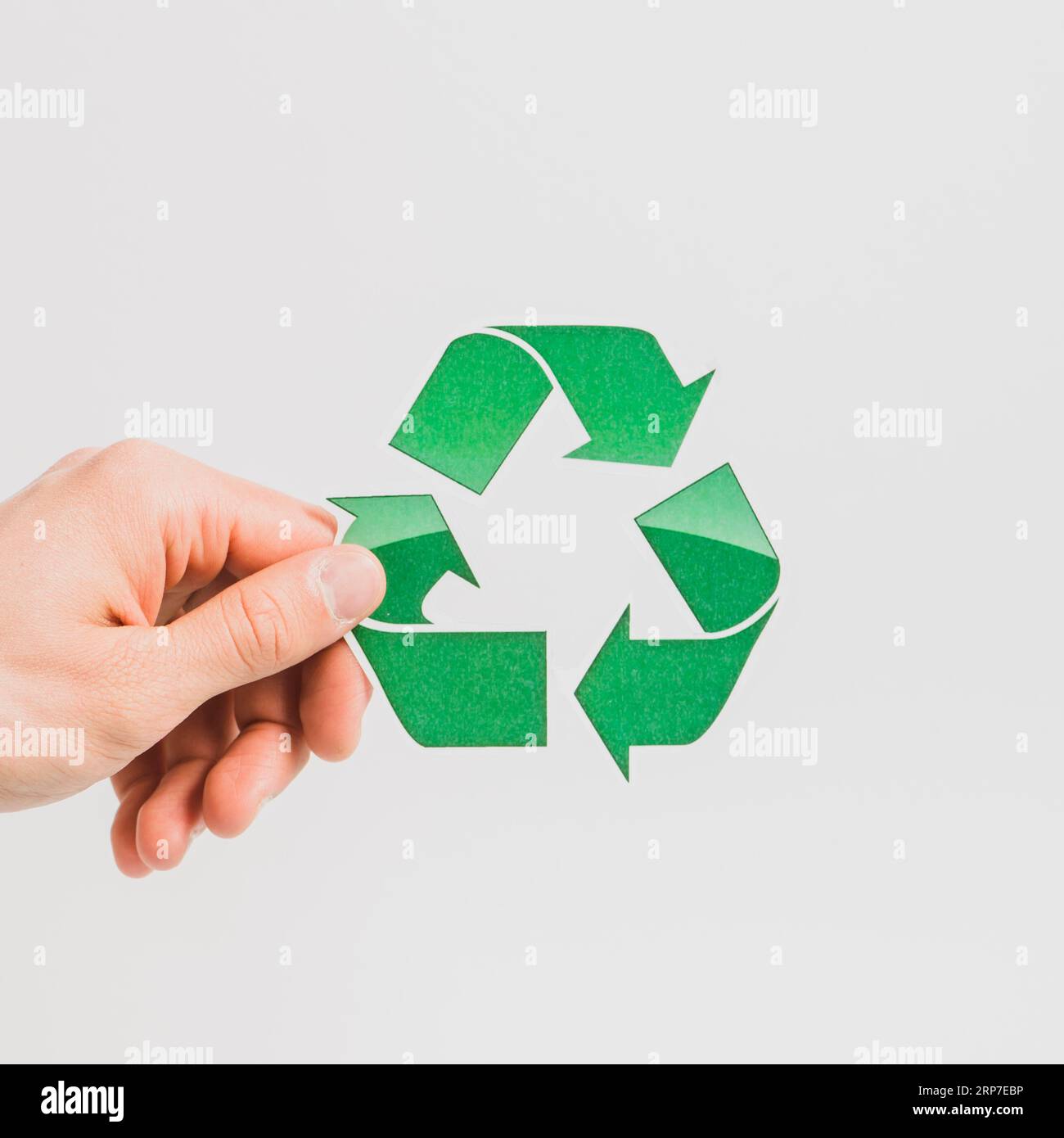 Person s hand holding green recycle symbol white backdrop Stock Photo ...