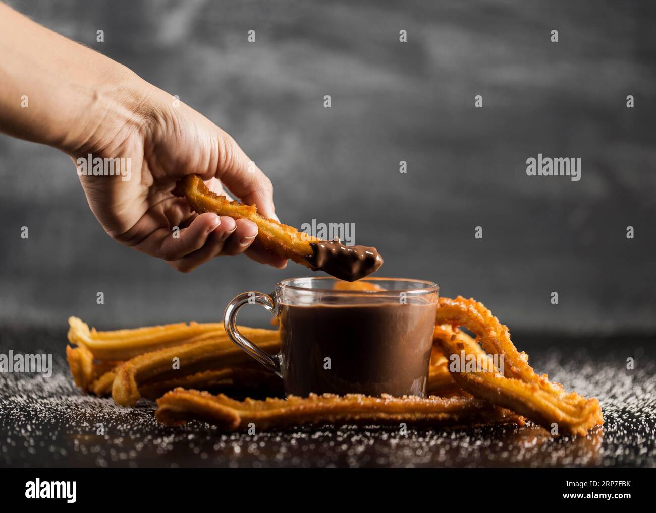 Hand dipping fried churros chocolate front view Stock Photo - Alamy