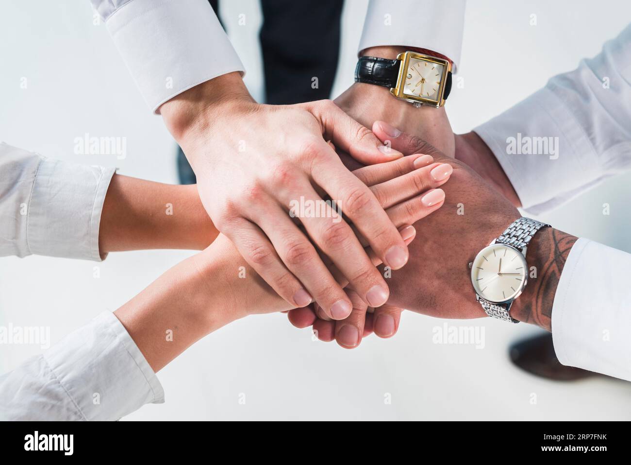 People putting stacked hands together promising help support against ...