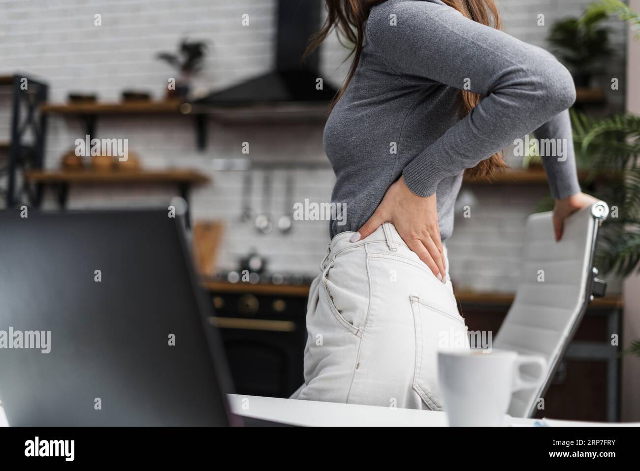 Side view woman having backache while working from home Stock Photo - Alamy