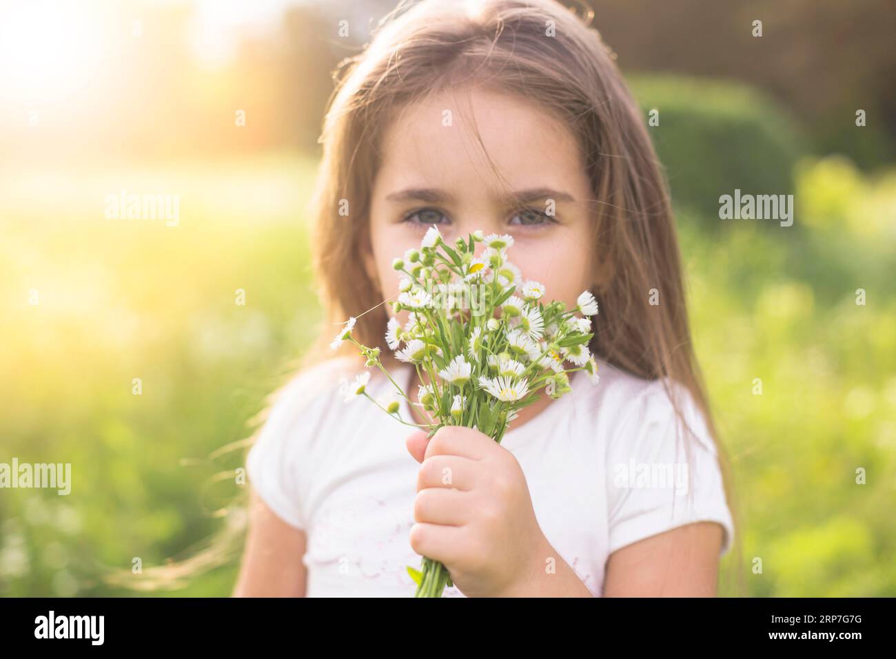Girl smelling white flowers Stock Photo - Alamy