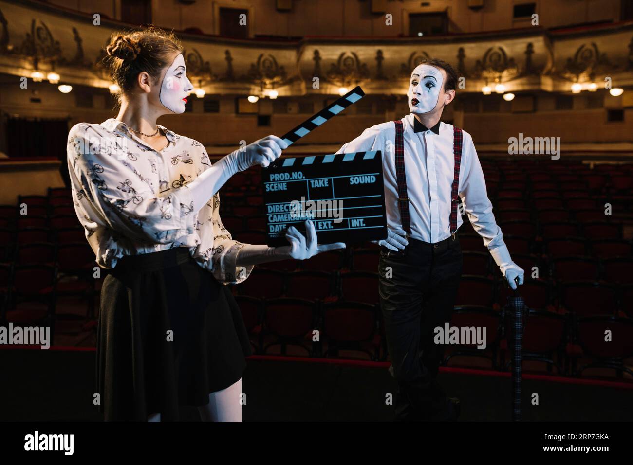 Female mime artist holding clapper front male mime artist performing ...
