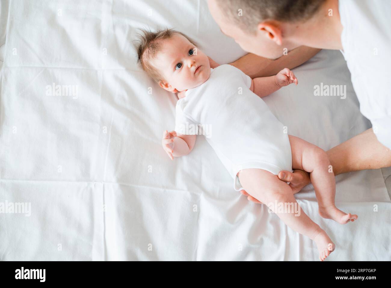 Father softly embracing baby bed Stock Photo - Alamy