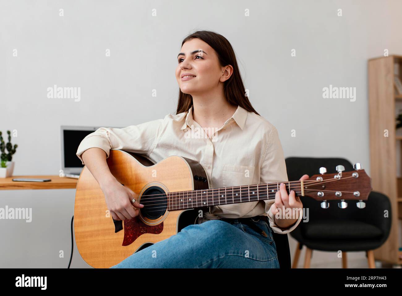 Front view smiley female musician playing acoustic guitar Stock Photo ...