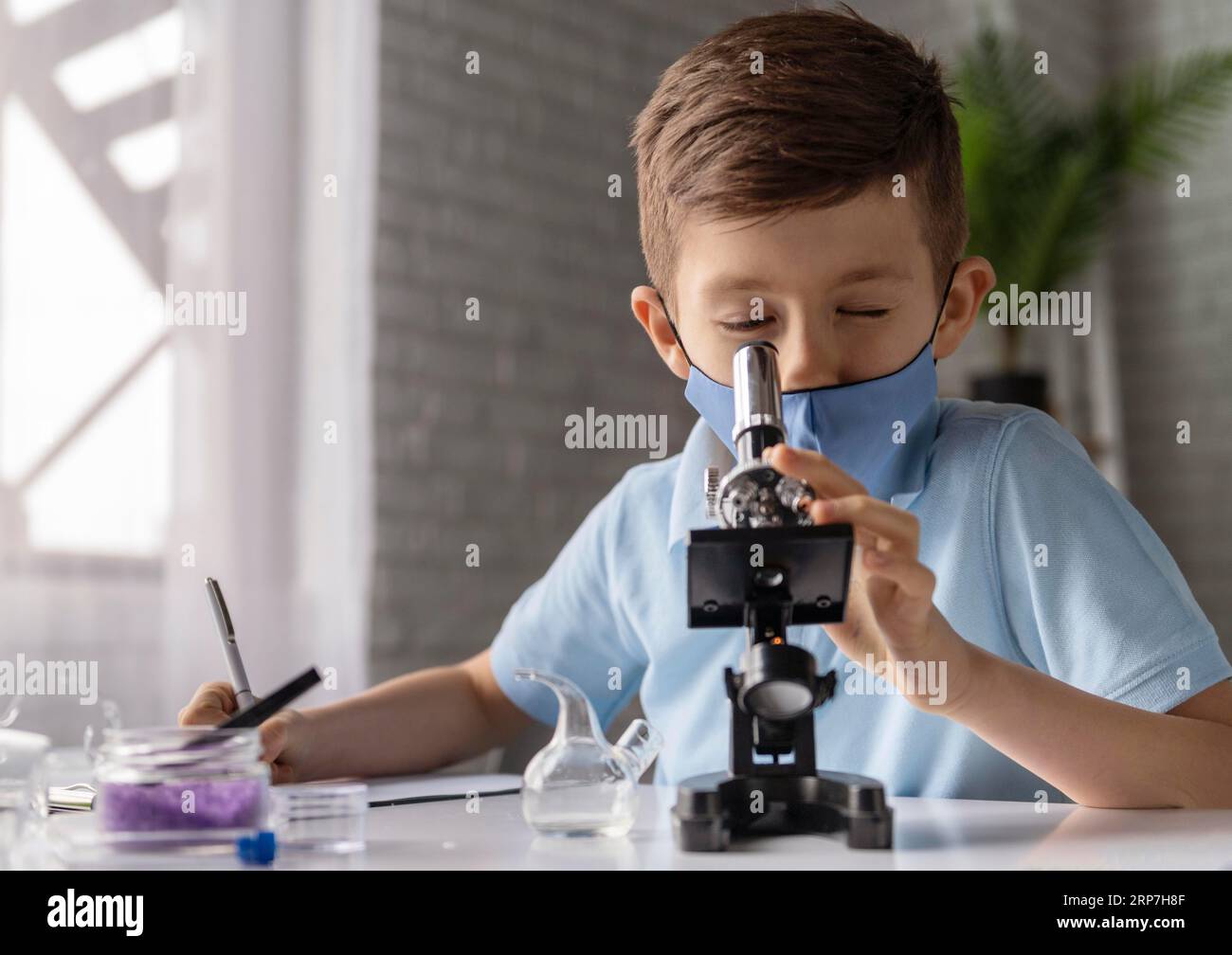 Medium shot kid looking through microscope Stock Photo - Alamy