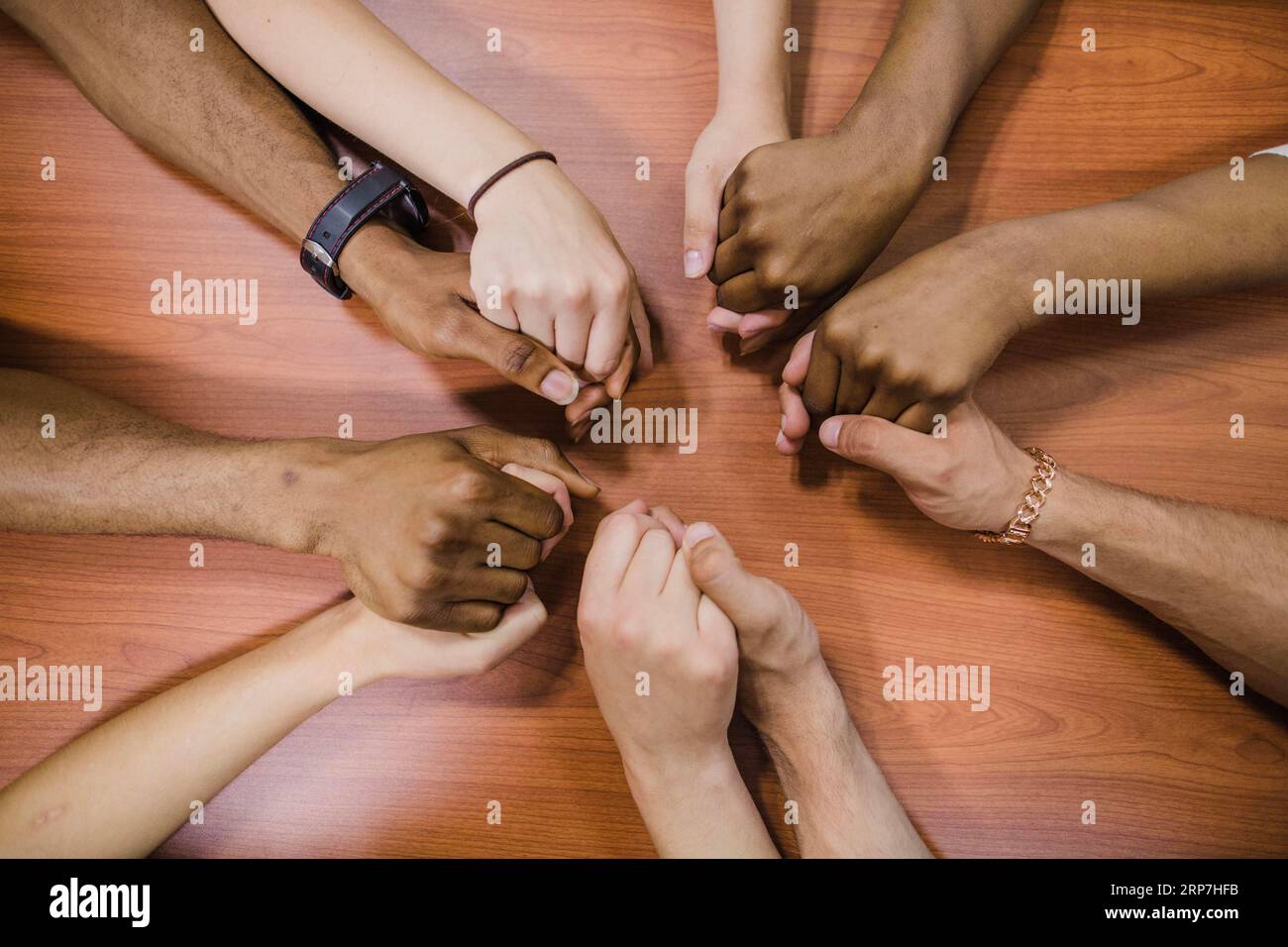 People holding hands table Stock Photo - Alamy