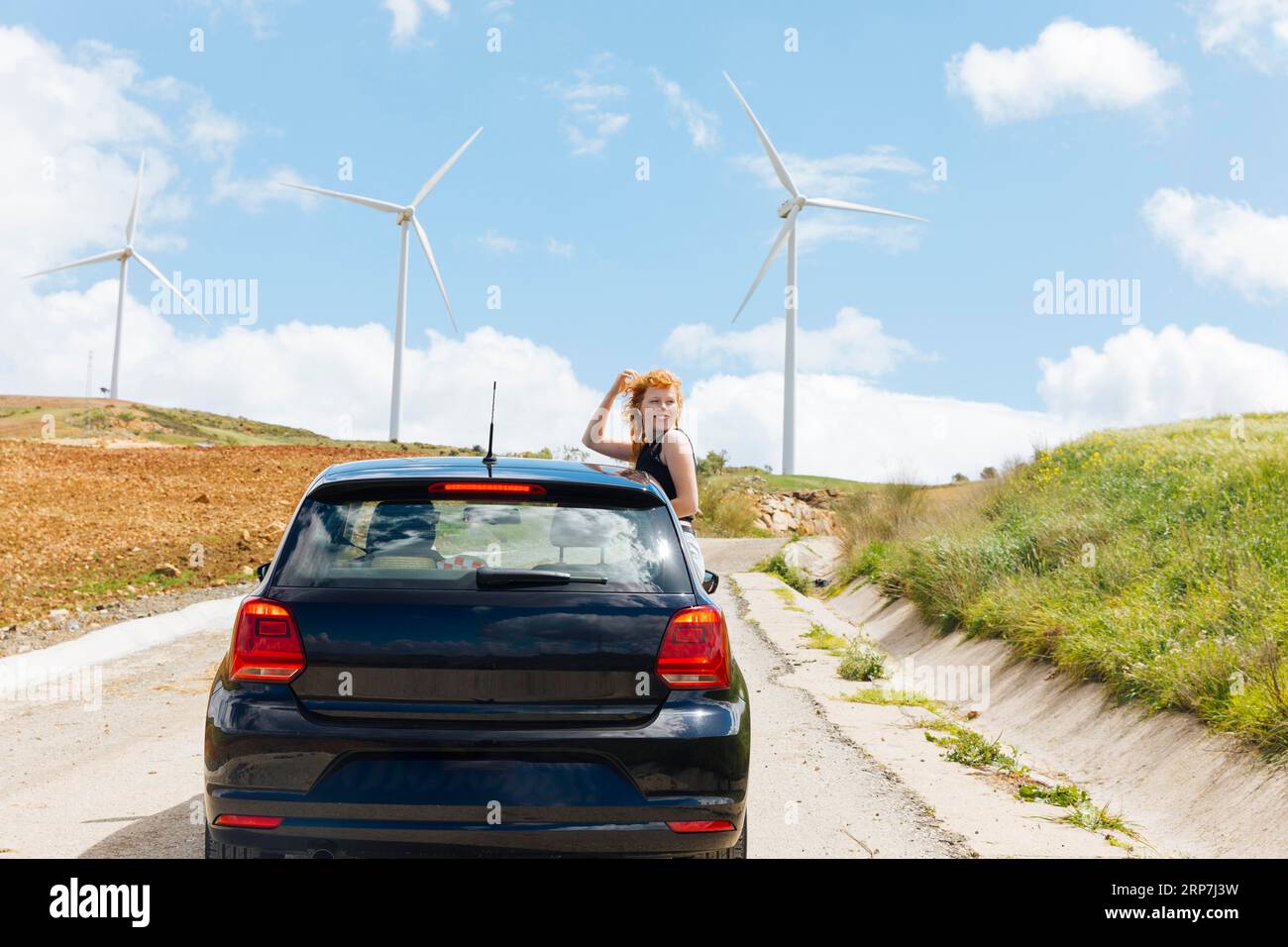 Woman looking back road out car window Stock Photo - Alamy