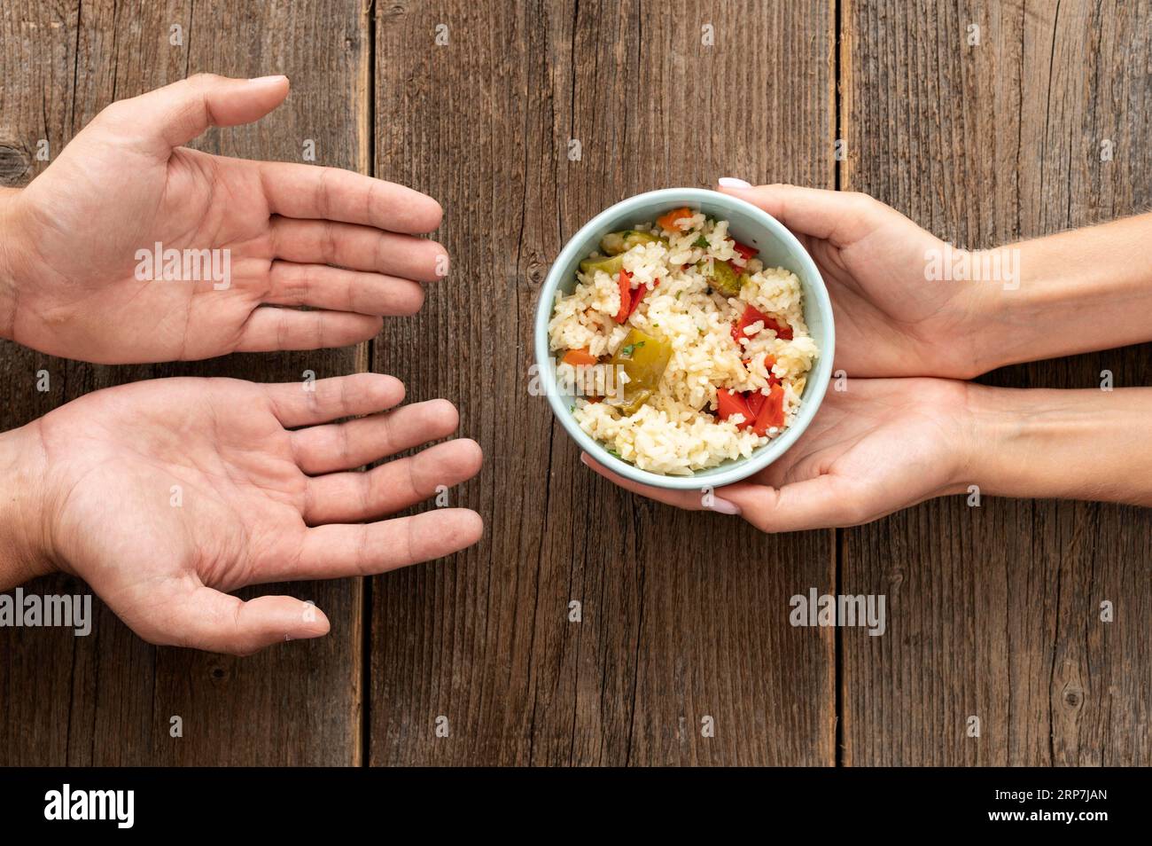 Hand giving bowl food needy person Stock Photo - Alamy