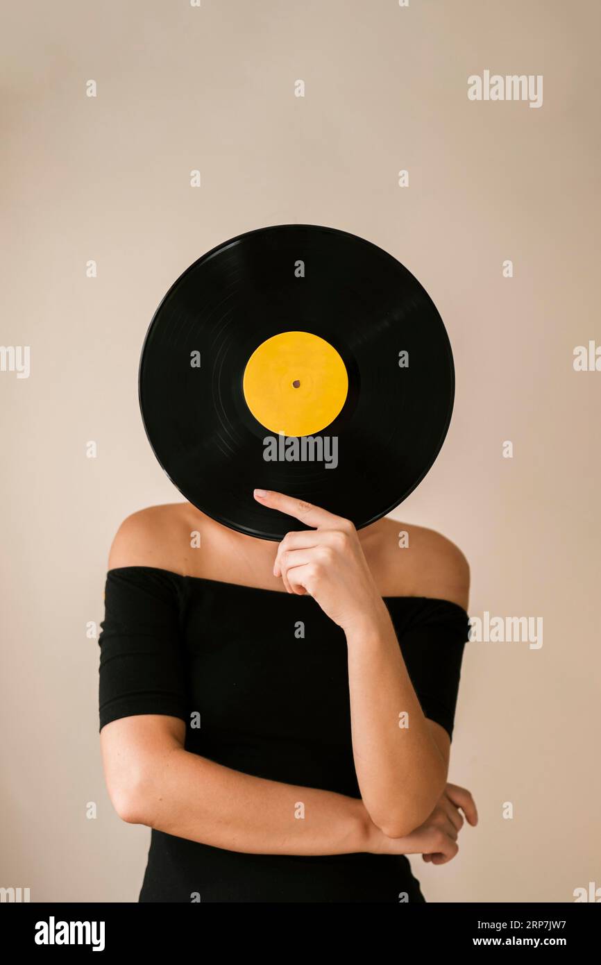 Young woman holding vinyl record her face Stock Photo - Alamy