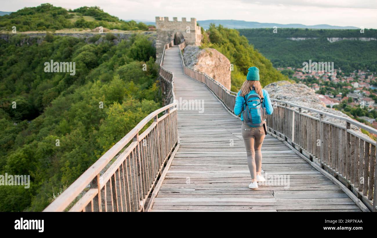 Back view traveller walking down bridge Stock Photo - Alamy