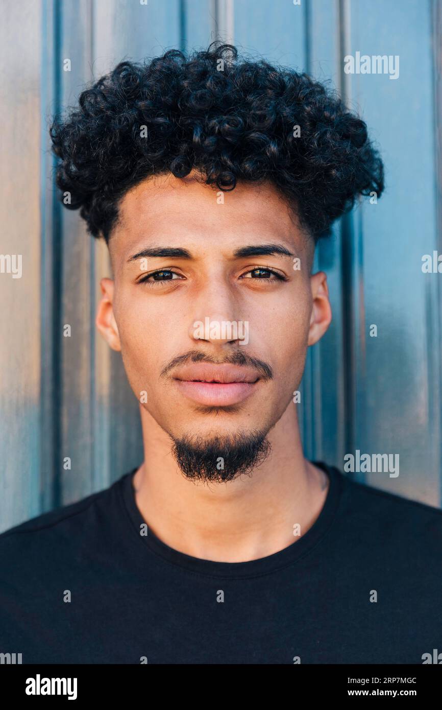Confident ethnic man with curly hair Stock Photo - Alamy