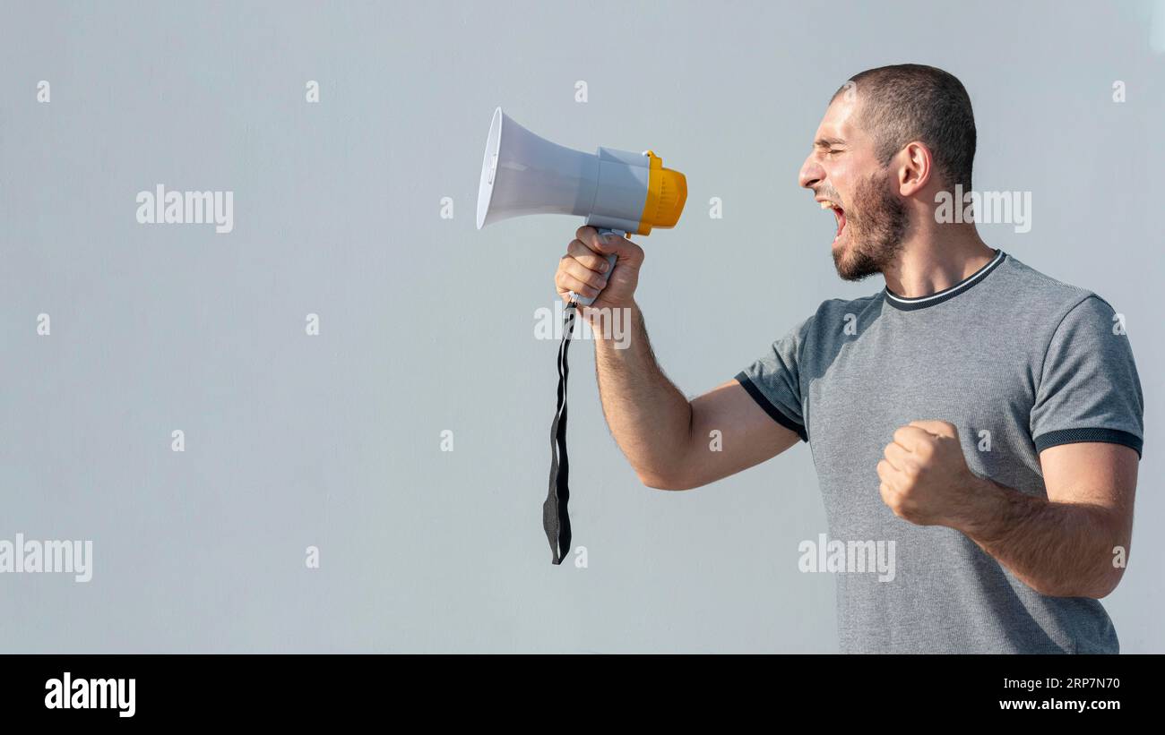 Front view protester with megaphone shouting Stock Photo - Alamy