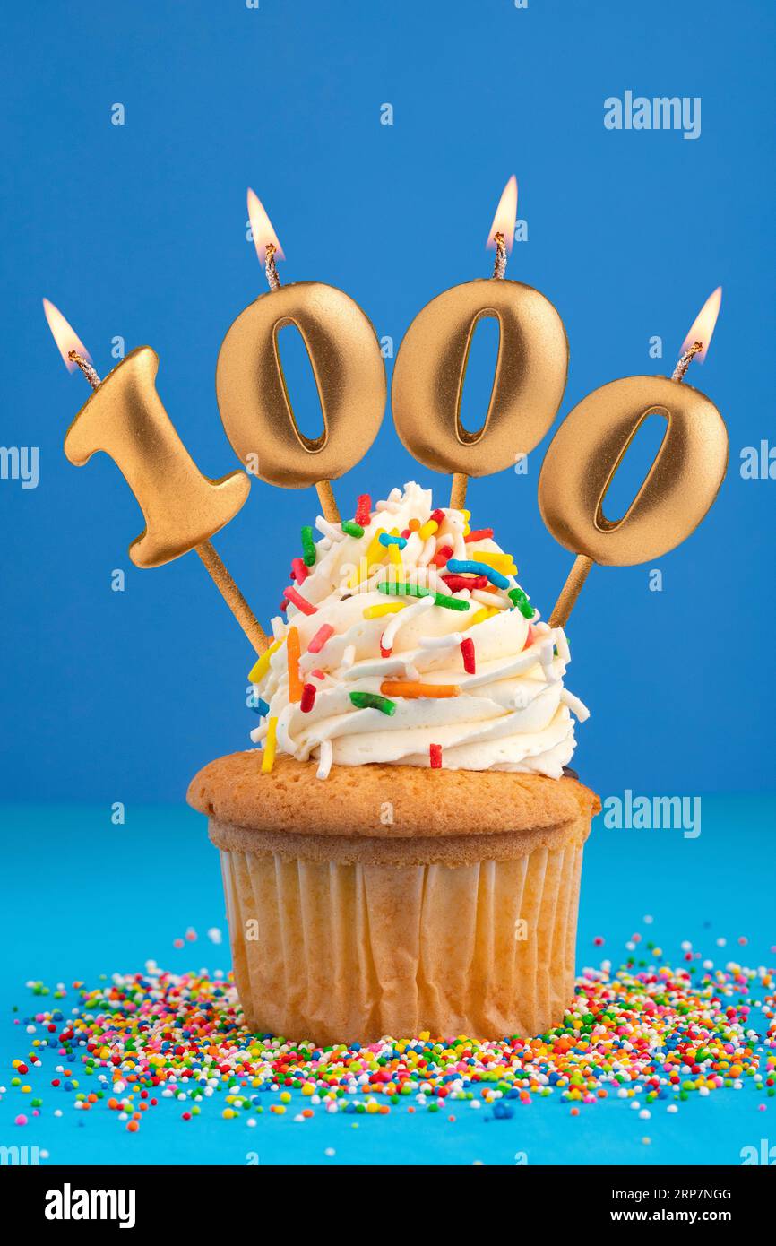 Candle number 1000 - Anniversary cupcake on blue background Stock Photo ...