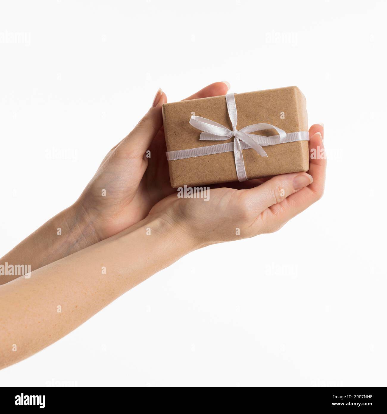 Hands holding gift with bow Stock Photo - Alamy
