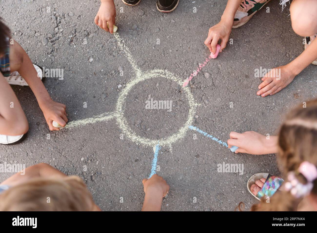 Kids drawing sun with chalk Stock Photo - Alamy