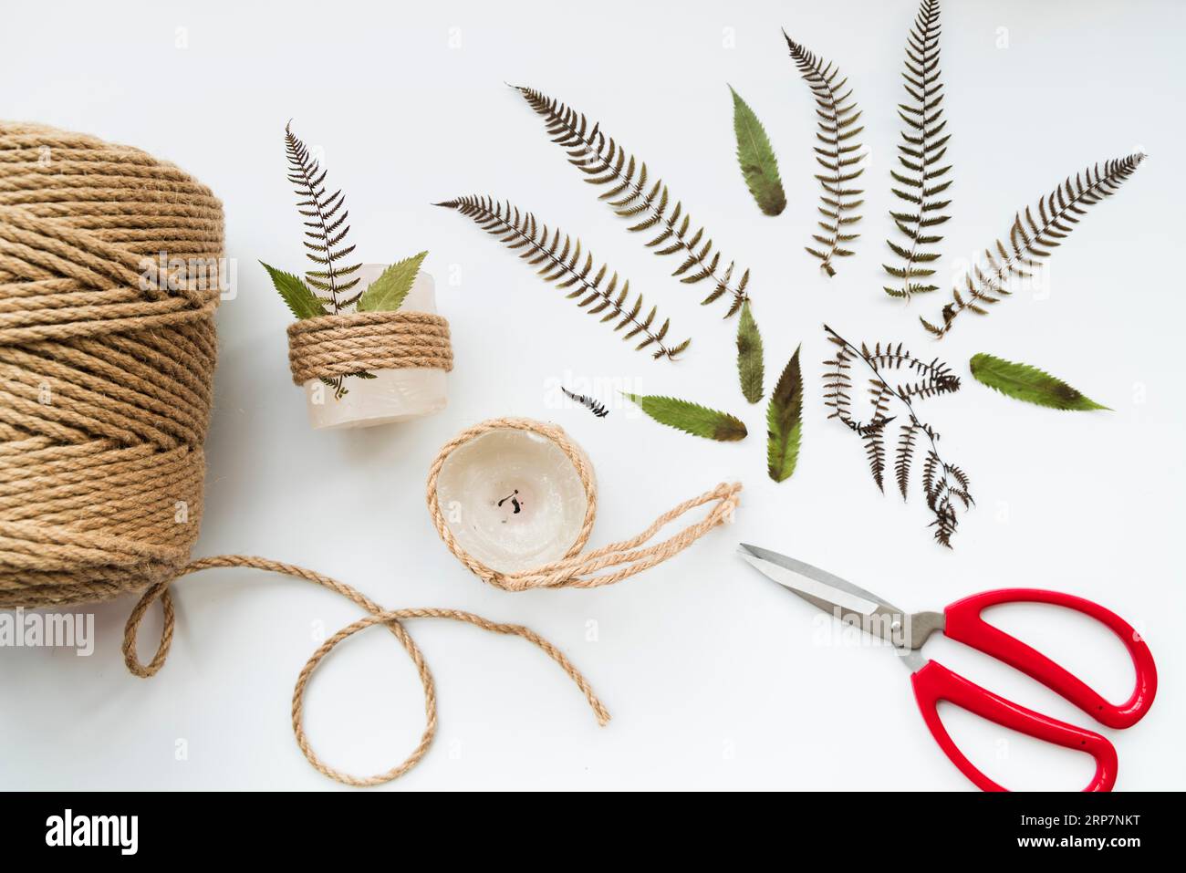 Leaves scissor jute string wrapped candles white background Stock Photo ...