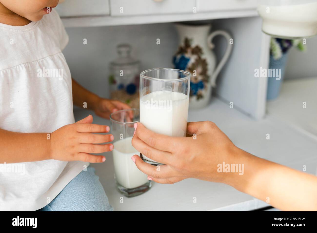 Mother hand offering glass milk Stock Photo - Alamy